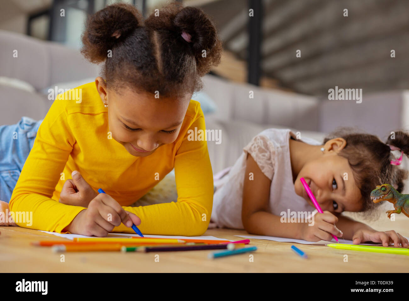 Positive delighted girl drawing picture for her mother Stock Photo - Alamy