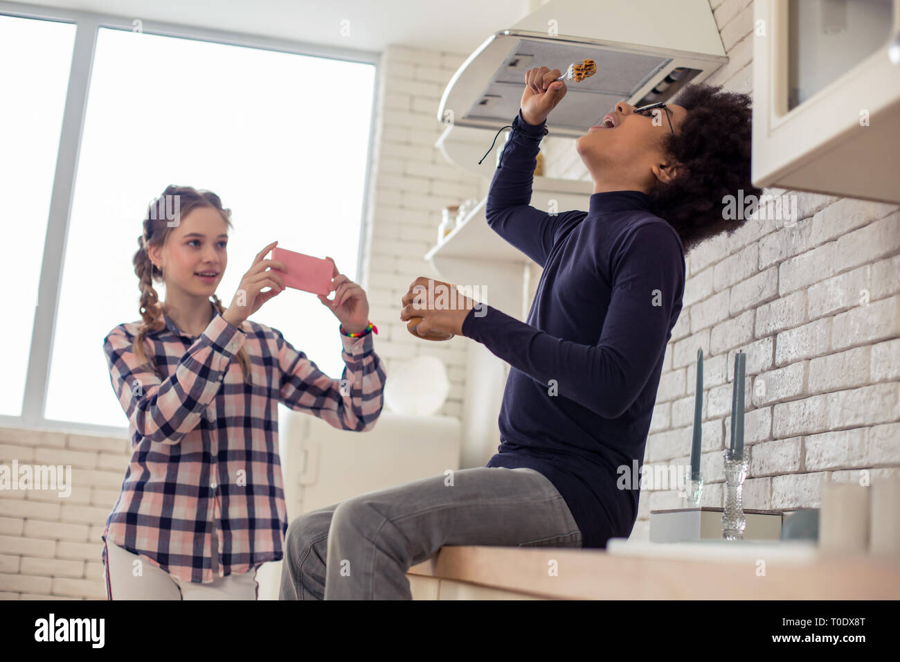 Positive delighted boy eating peanut paste with pleasure Stock Photo ...