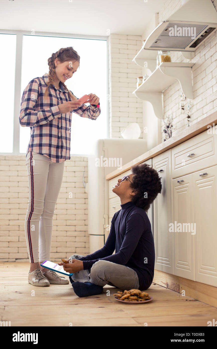 Pleased tall girl taking photo of her friend Stock Photo - Alamy