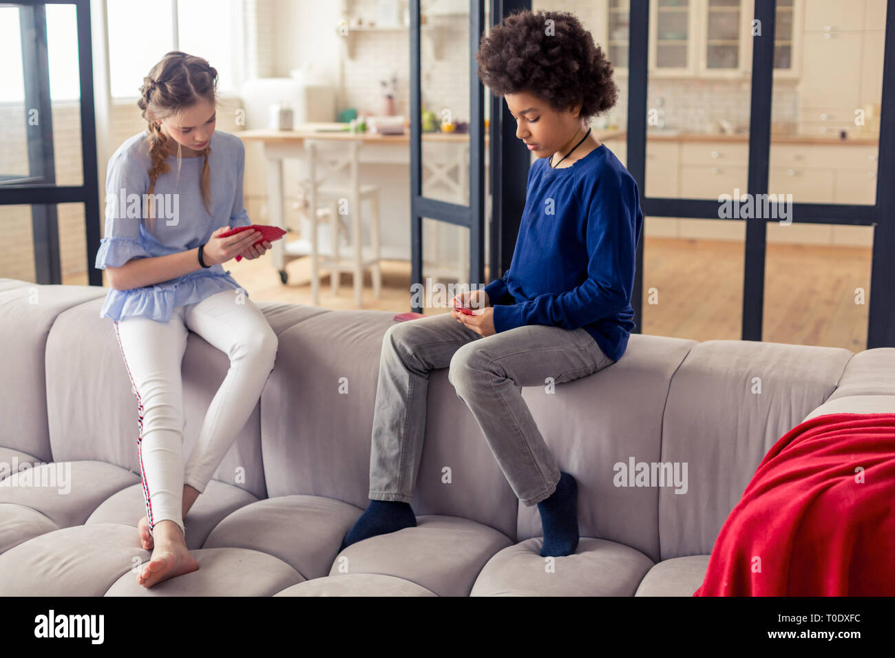 Concentrated boy sitting in semi position on sofa Stock Photo - Alamy