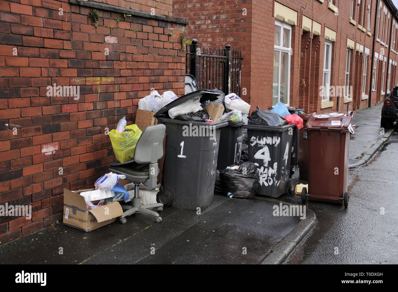 Bins on pavement with excess rubbish around them awaithing collection ...
