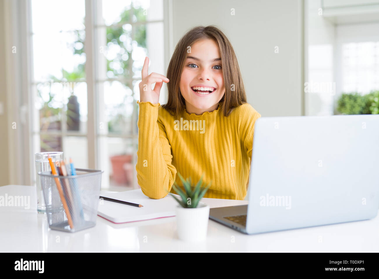 Beautiful young girl studying for school using computer laptop ...