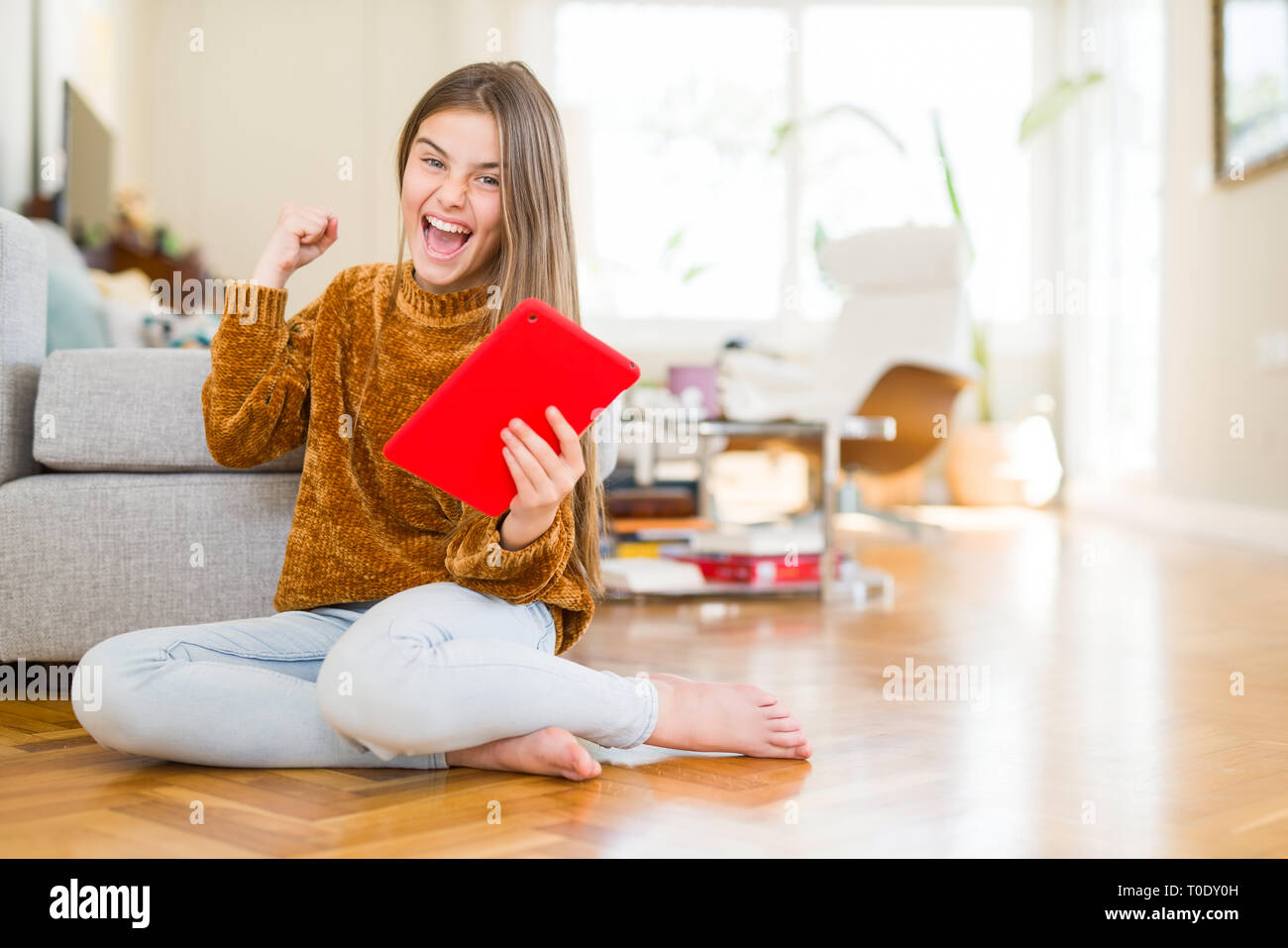 Beautiful young girl kid using digital touchpad tablet sitting on the ...