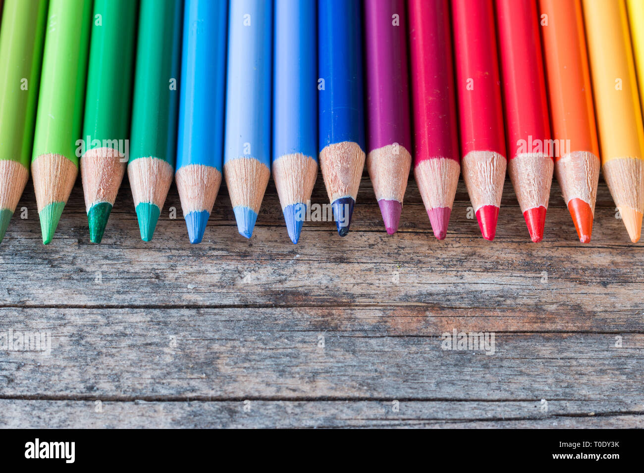 Set of multi-colored pencils on a rustically wooden table, copy space ...