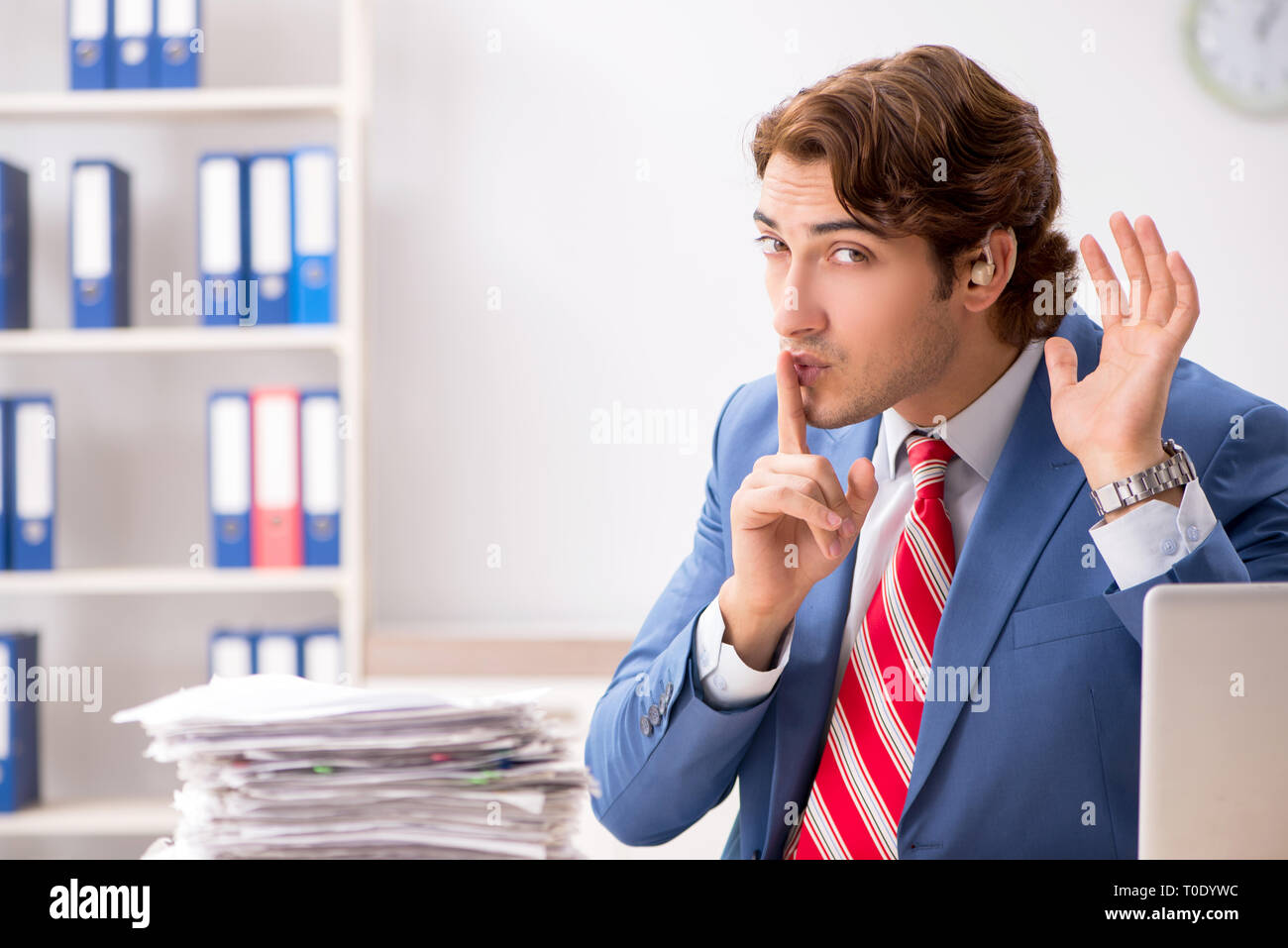 Deaf employee using hearing aid in office Stock Photo - Alamy