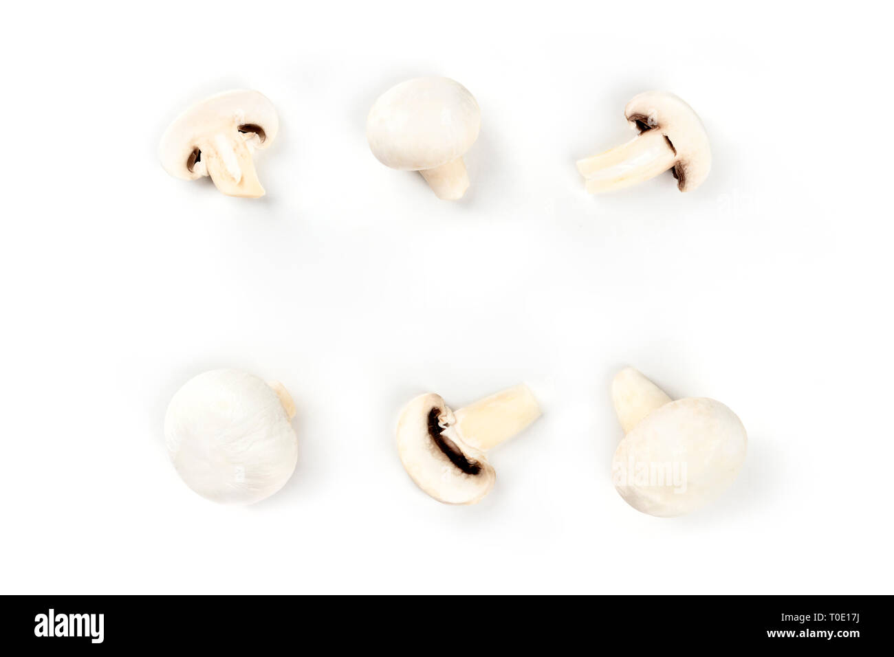 Champignon mushrooms, whole and sliced, shot from above on a white ...