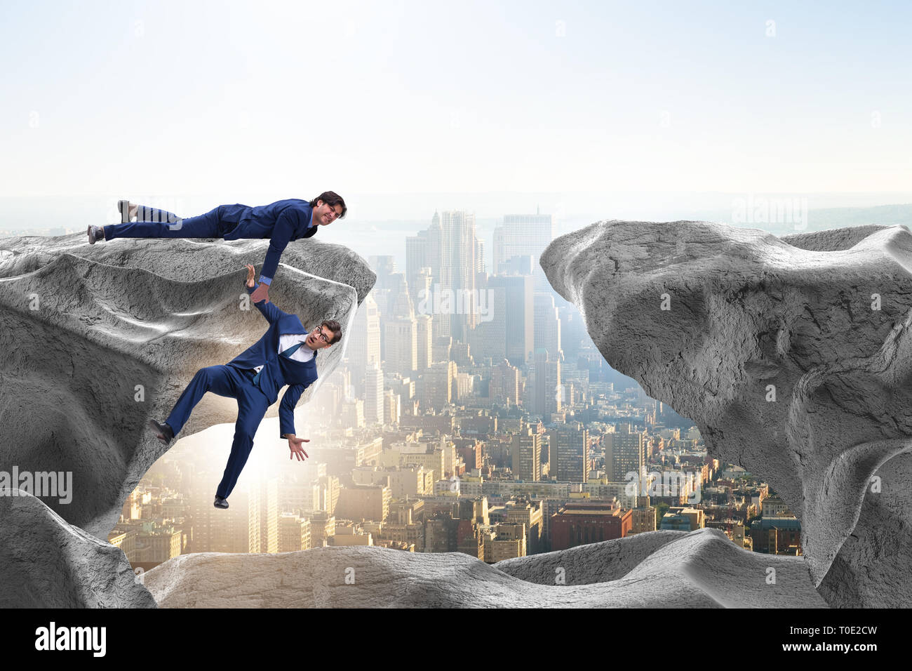 Businessman offering helping hand to falling colleague Stock Photo - Alamy