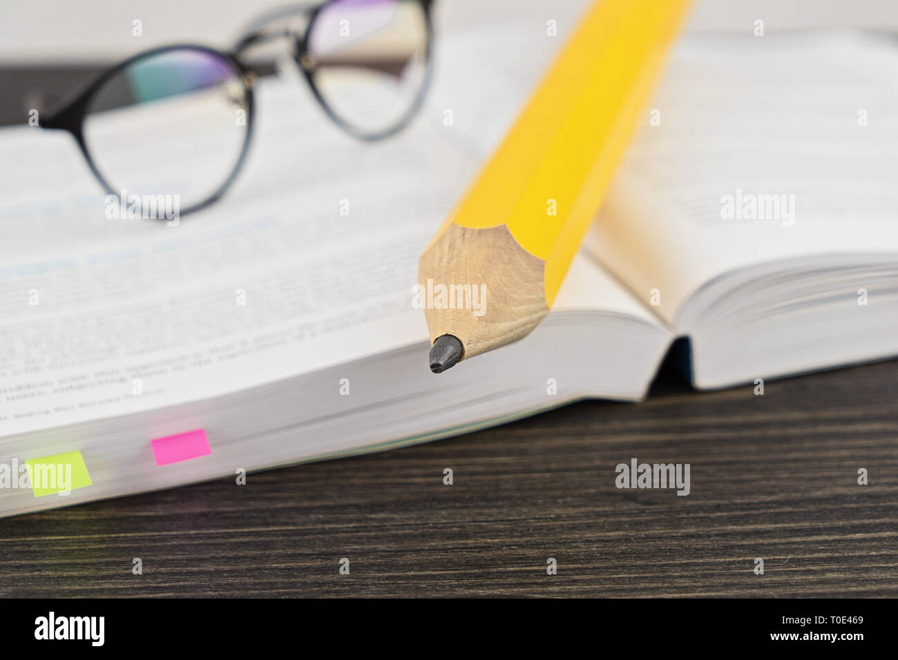Reading glasses on an open book with big yellow pencil, DOF Shallow ...