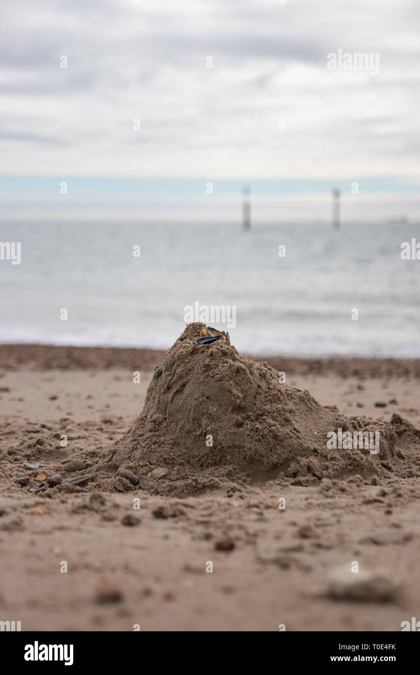 Sandcastle washed away by the tide on British beach Stock Photo - Alamy