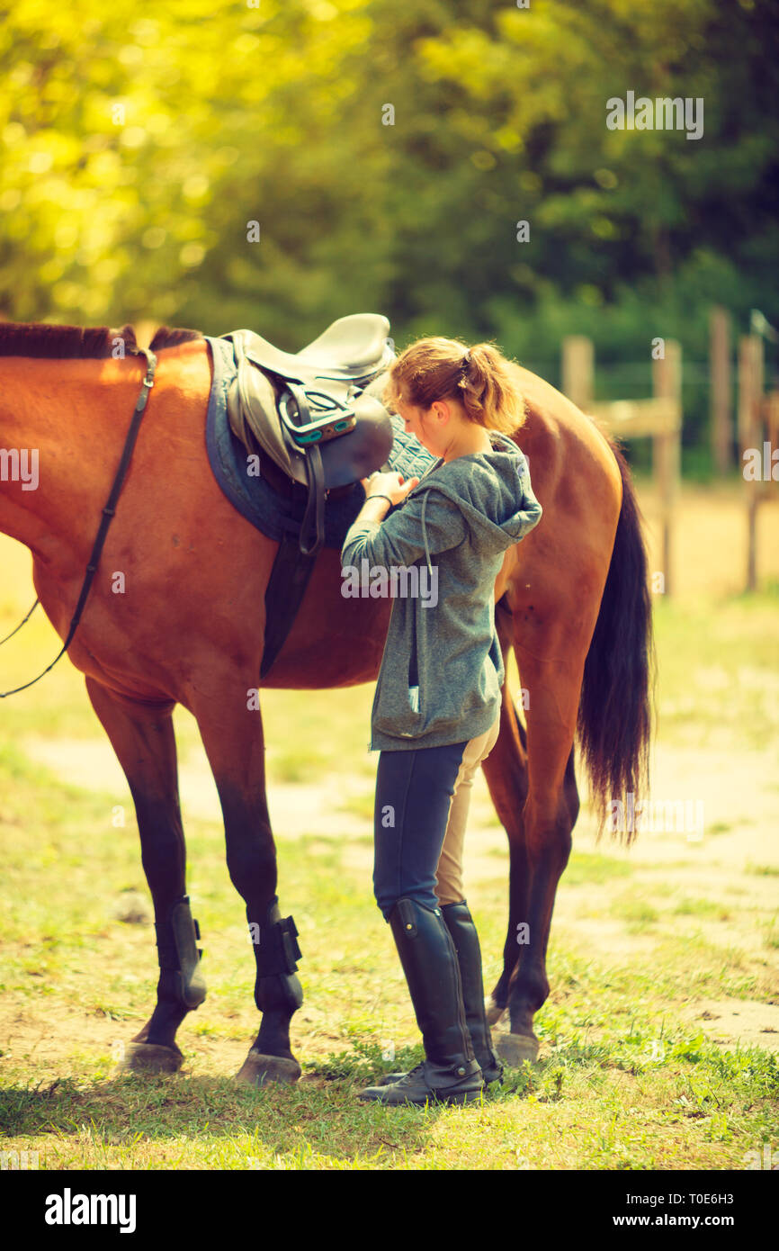 Taking care of animals, horsemanship, equine concept. Cowgirl getting ...