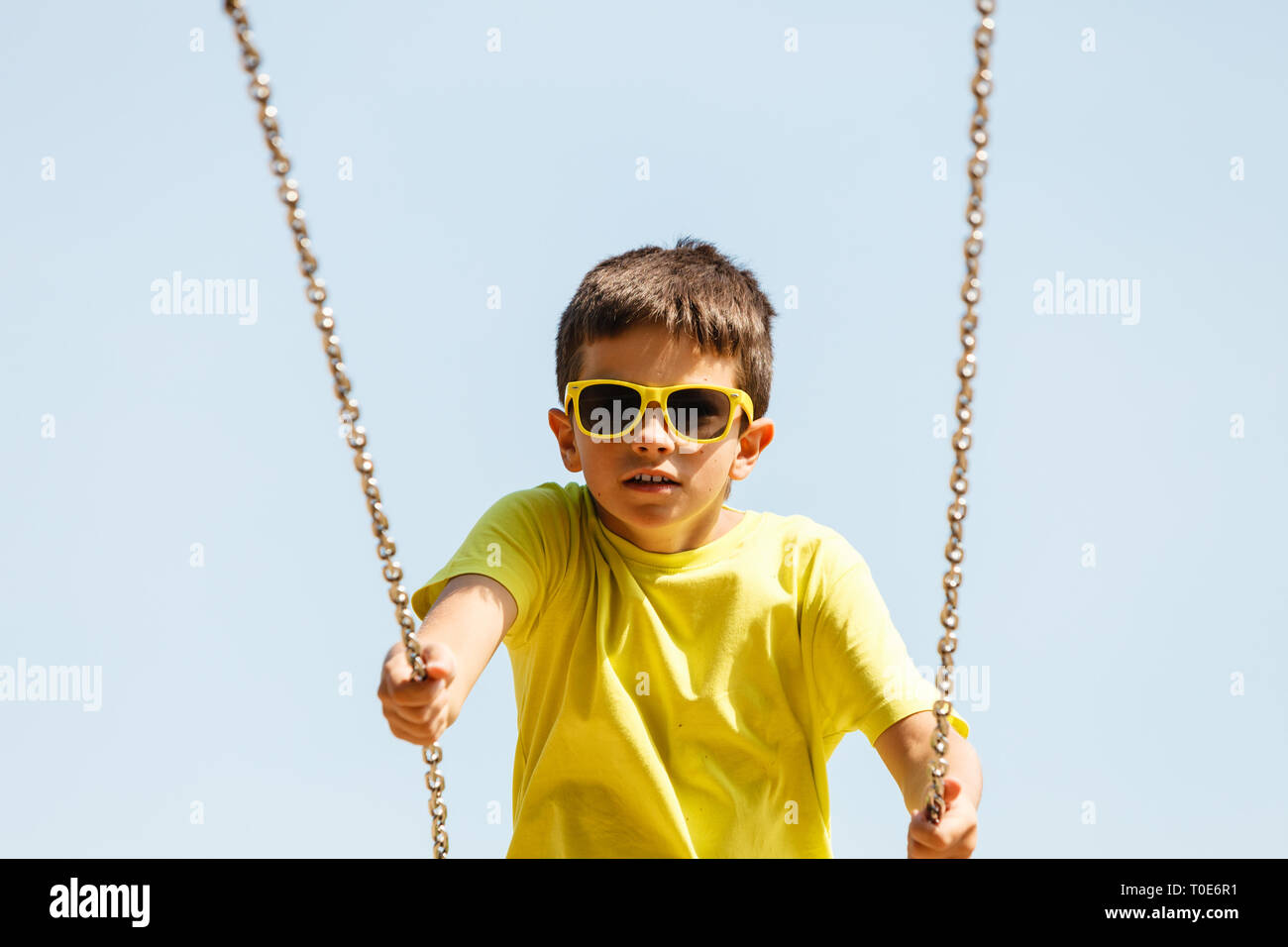 Rest and relax for children. Little boy in sunglasses resting swinging ...