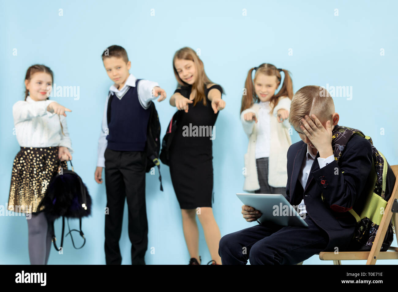 Little boy sitting alone on chair and suffering an act of bullying ... Little boy sitting alone on chair and suffering an act of bullying ...