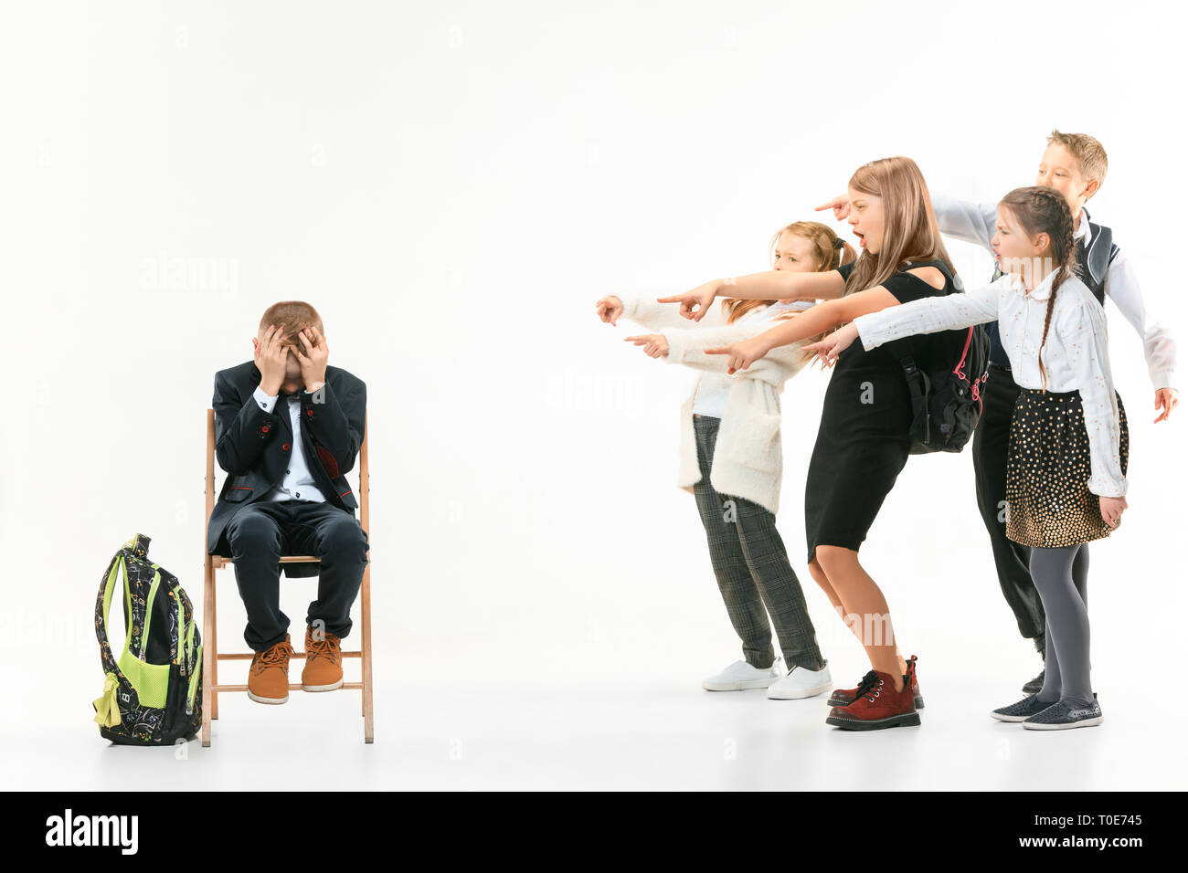 Little boy sitting alone on chair and suffering an act of bullying ...