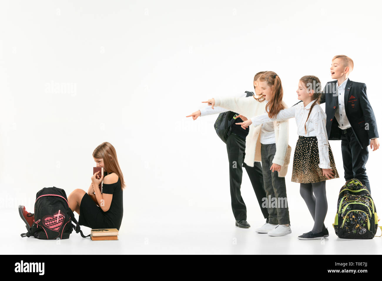 Little girl sitting alone on floor and suffering an act of bullying ...