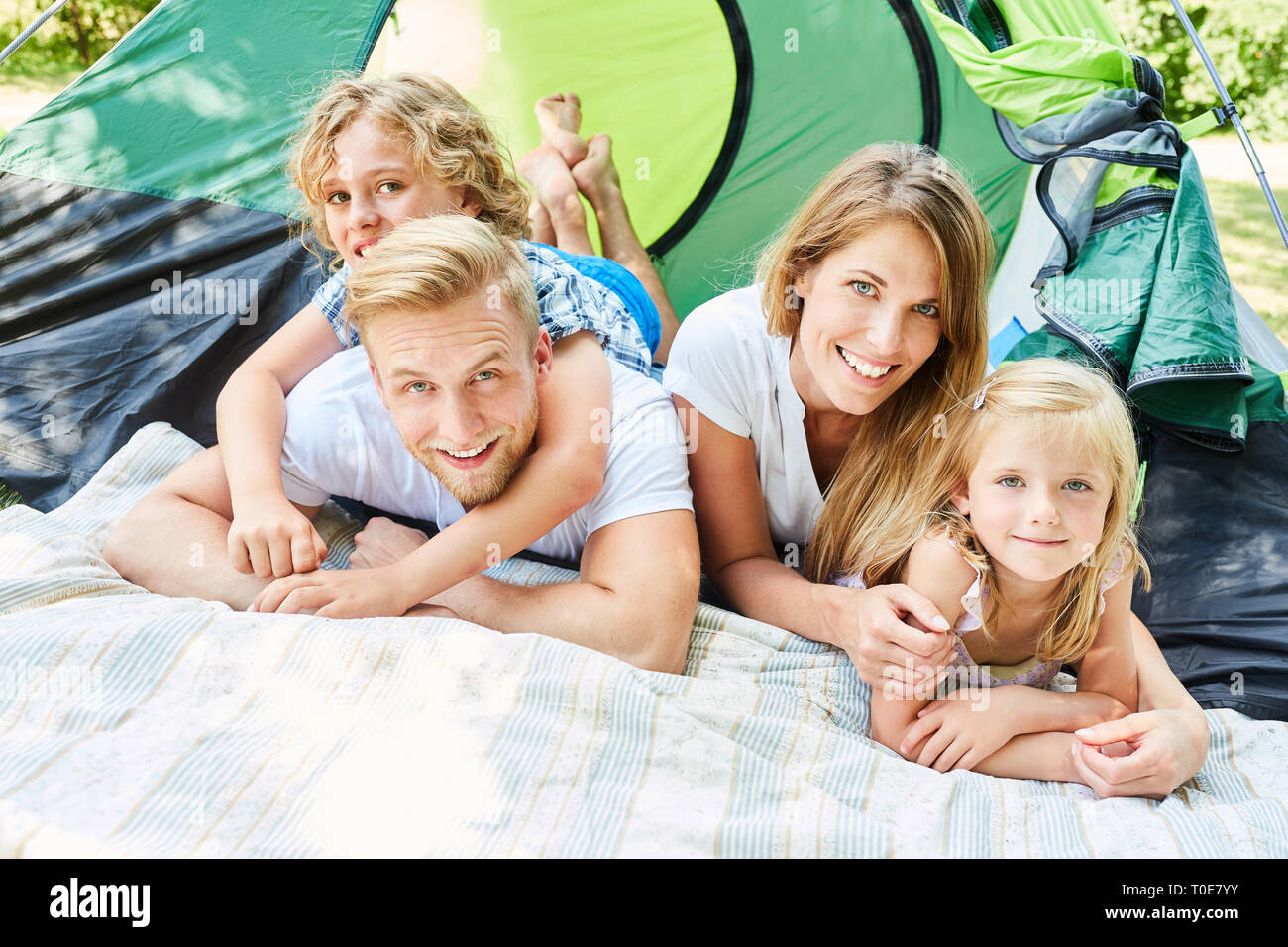 Laughing family with two children in tent on summer vacation Stock ...