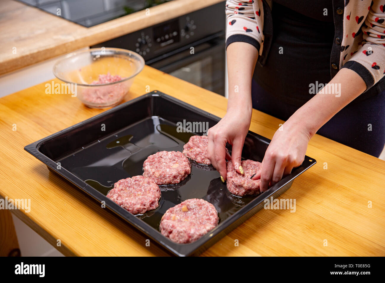 Young woman cooking meatballs or cutlets in modern kitchen. Woman ...