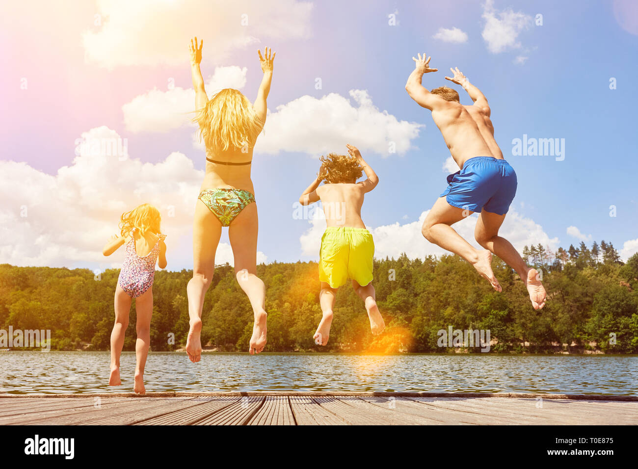 Family Together Jumping In Water At Beach Stock Photos & Family ...