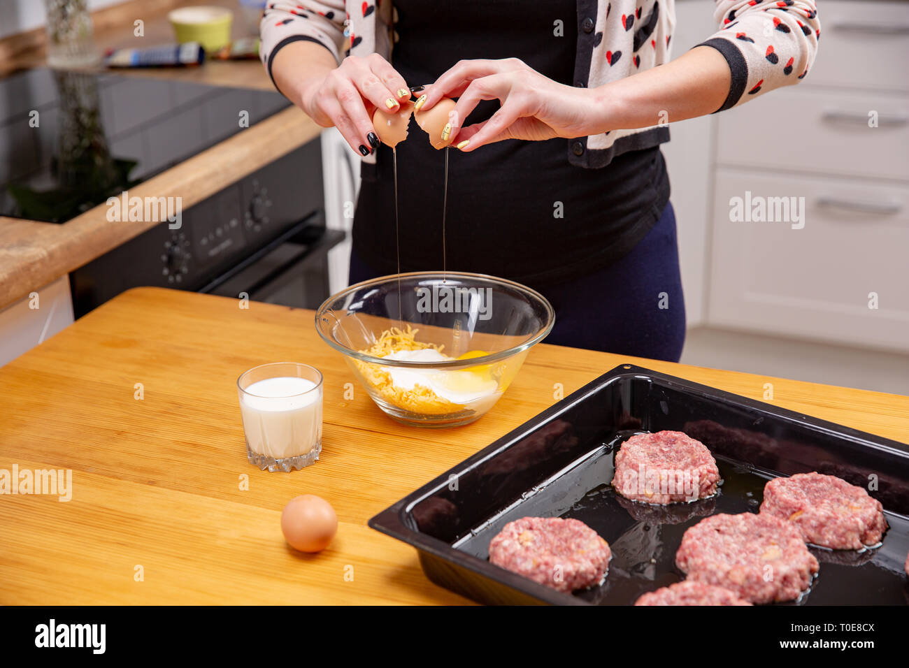 Black woman breaking egg in kitchen hi-res stock photography and images - Alamy