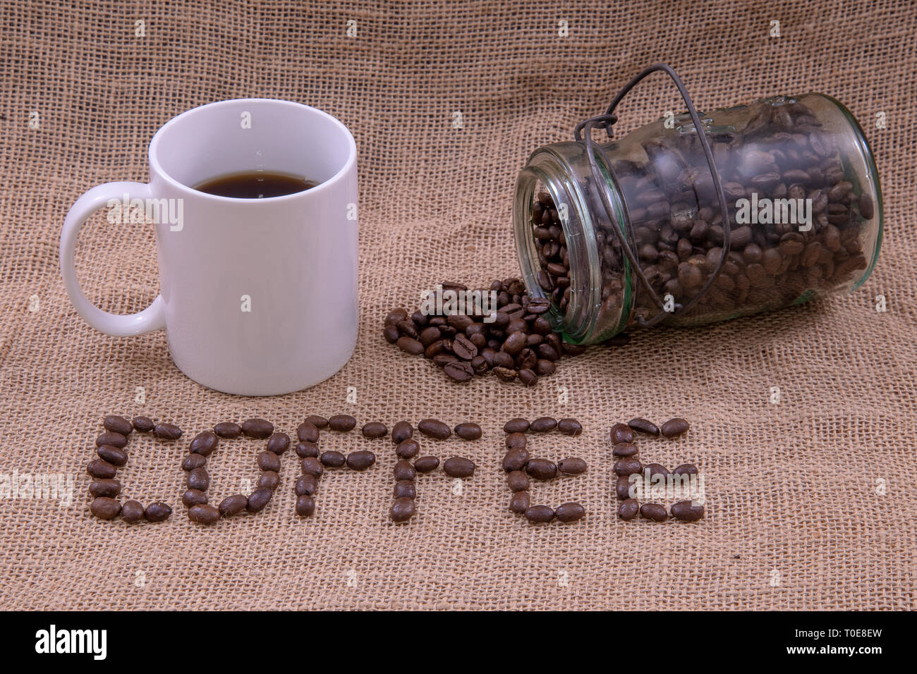 Coffee beans that spell coffee, a coffee mug, and a jar with beans ...