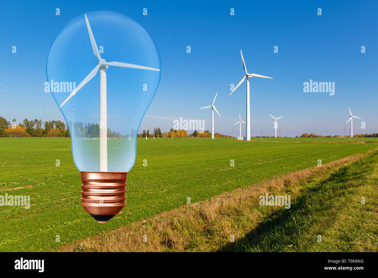 Light bulb with wind turbine inside on the background of blue sky and ...