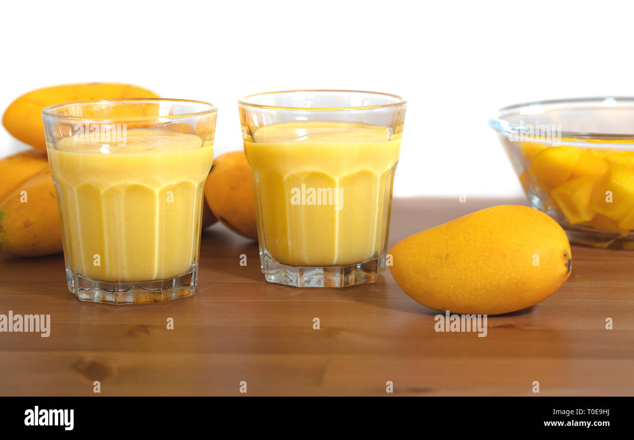 Mango milkshake in glass made with yellow baby Mangoes with white ...