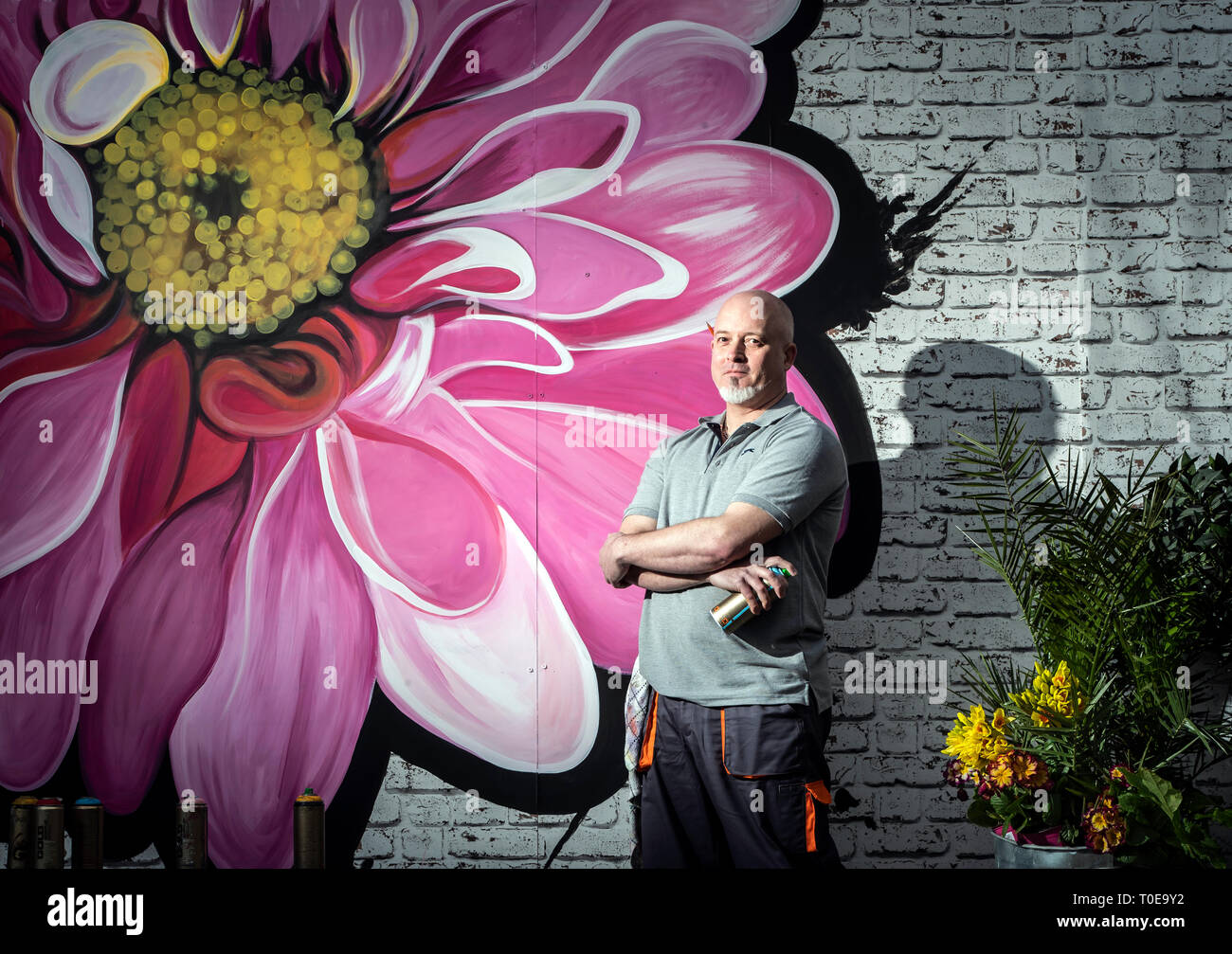 Mural artist Lee Ferry with one of his flower murals during the press ...
