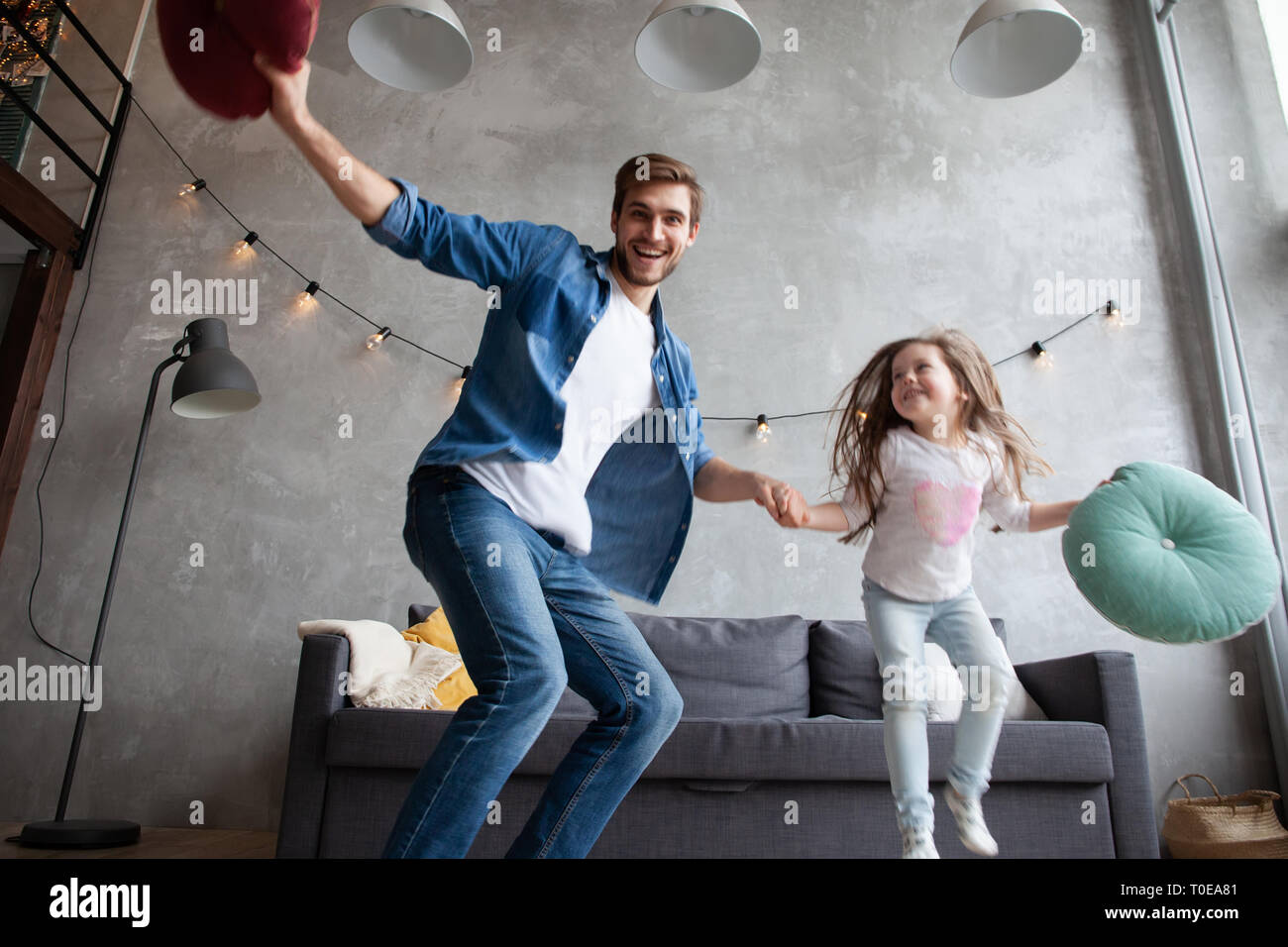 Funny father and cute kid daughter laughing jumping having fun in ...