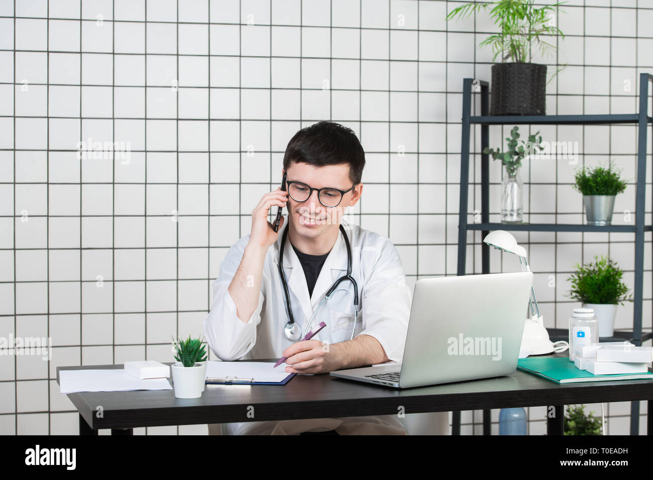 Doctor talking on phone using hi-res stock photography and images - Alamy