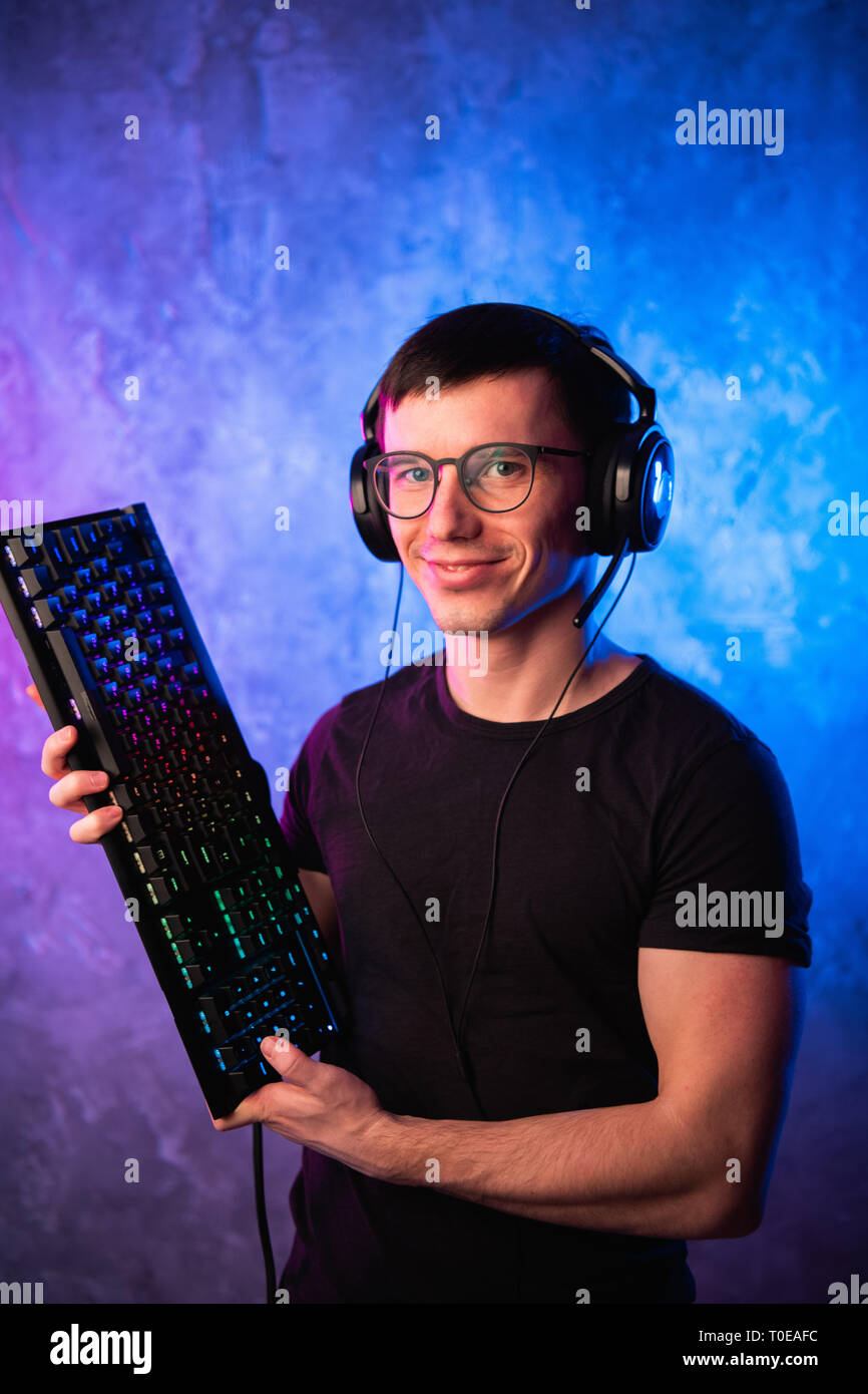 Professional Boy Gamer holding gaming keyboard over colorful pink and ...
