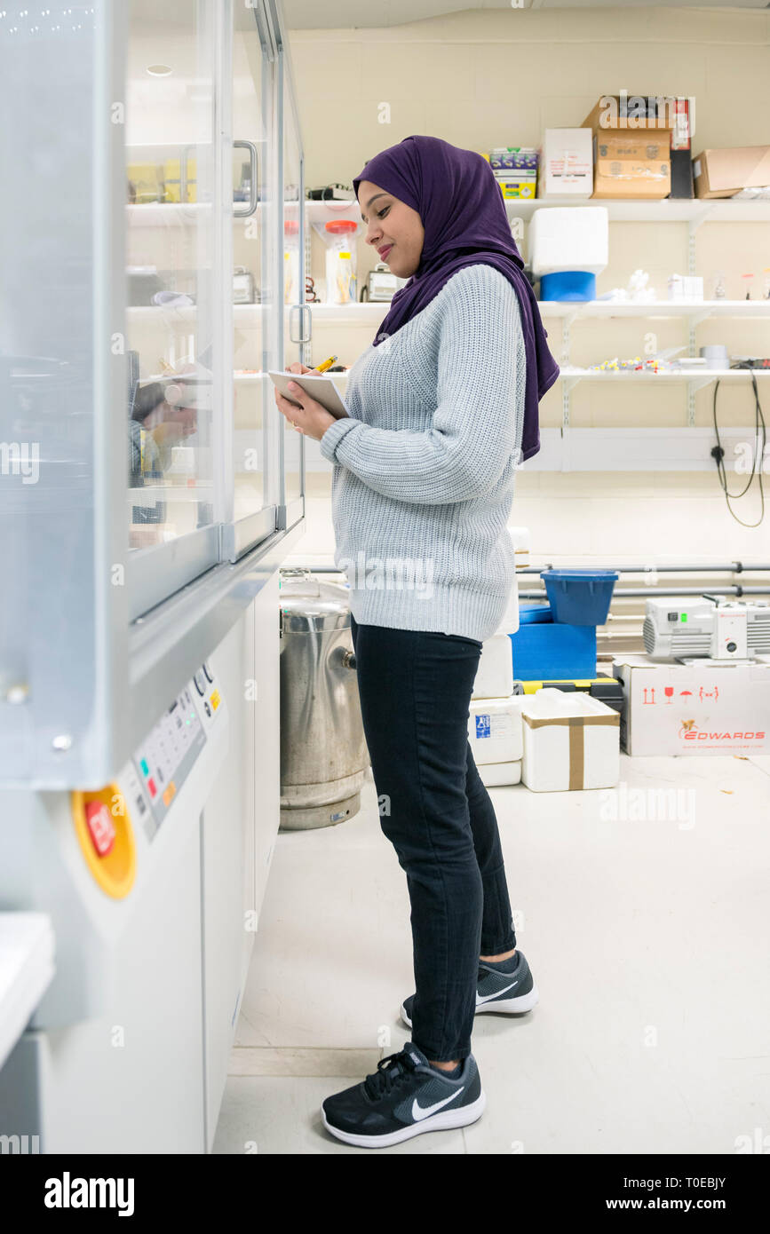 A muslim woman uses the scientific equipment in a research laboratory ...