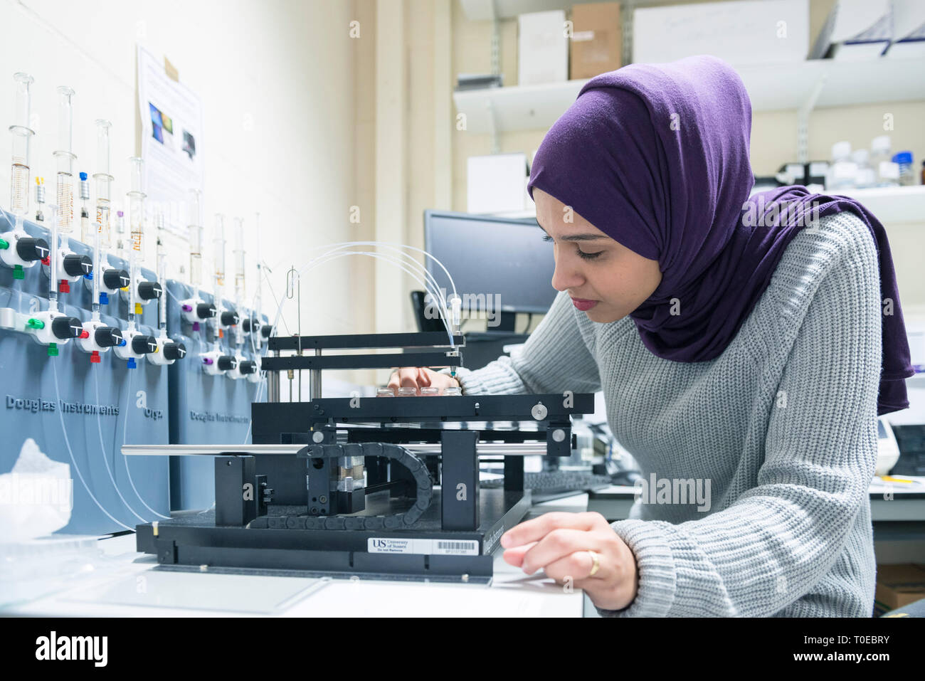 A muslim woman uses the scientific equipment in a research laboratory ...