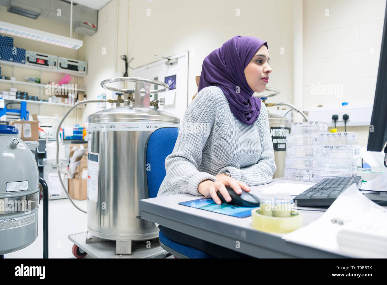 A muslim woman uses the scientific equipment in a research laboratory ...