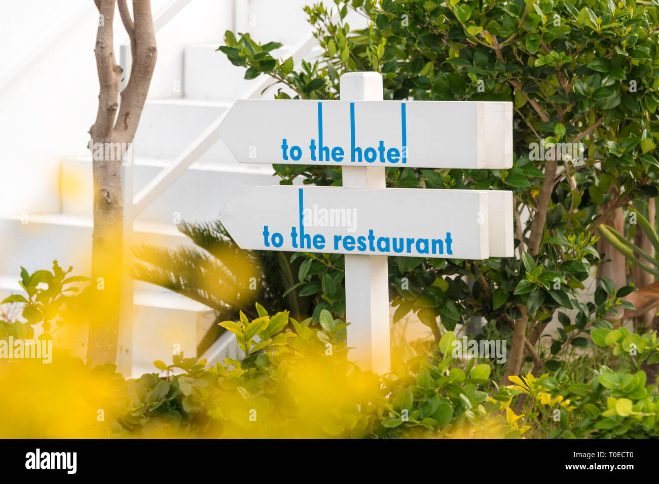 Wooden sign in the garden showing the way to the hotel and restaurant ...