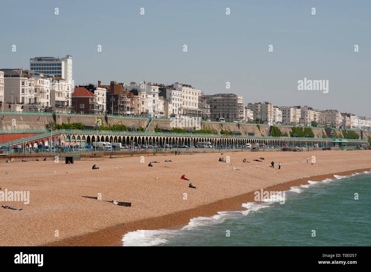 View of the beach and victorian arches in the seaside town of Brighton ...