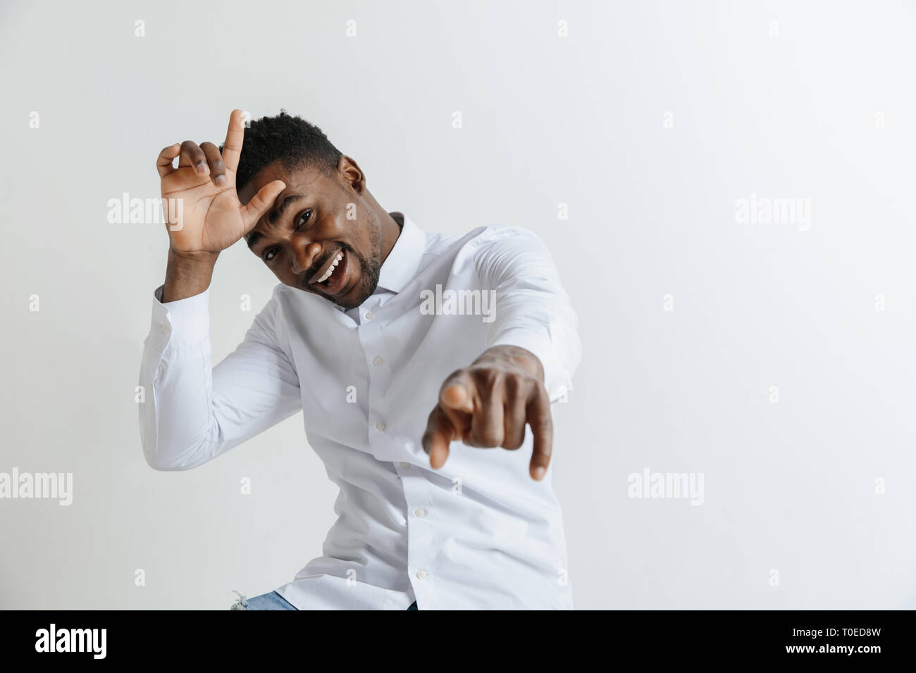 Losers go home. Portrait of happy guy showing loser sign over forehead ...