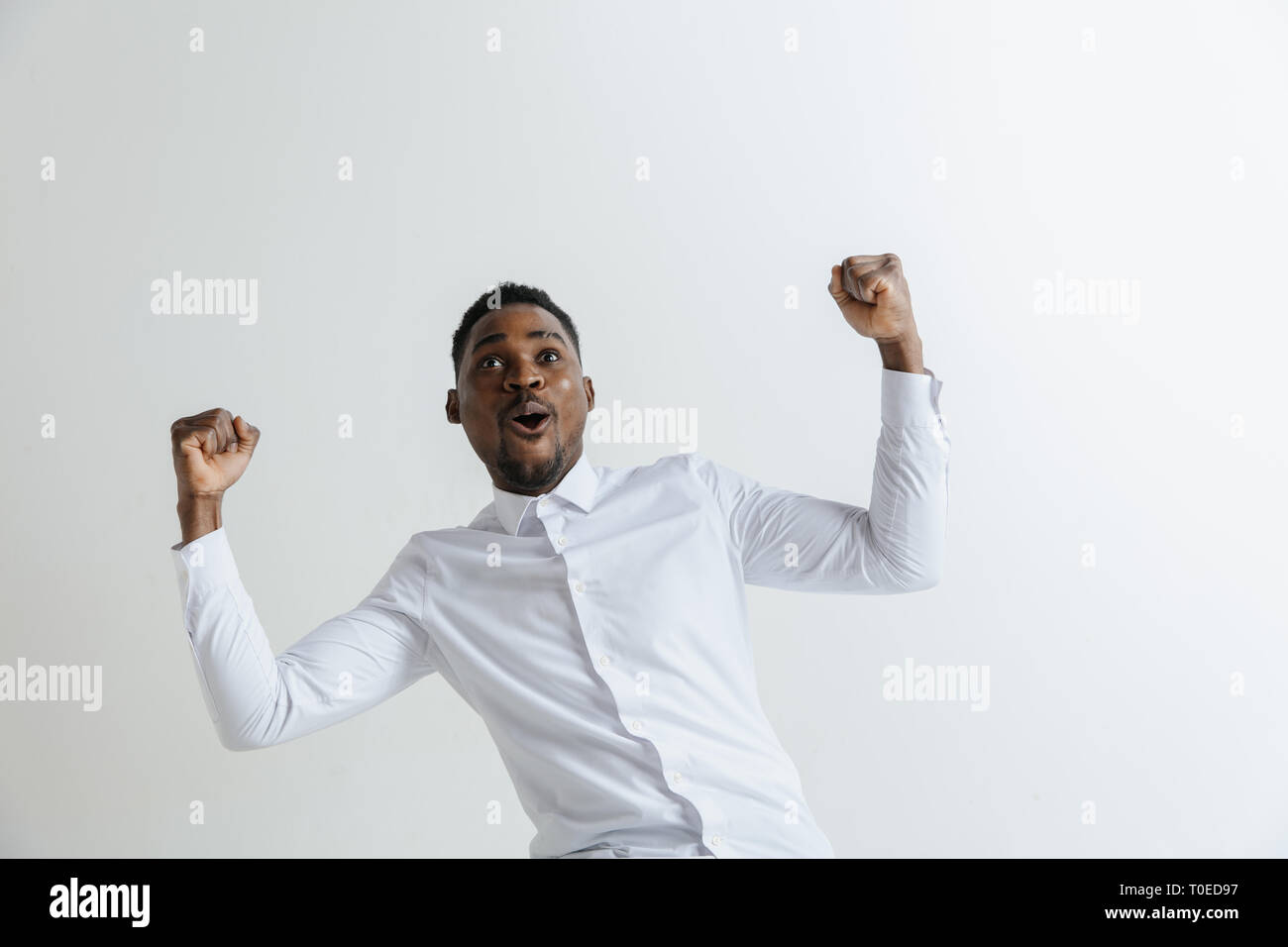Portrait of excited young African American male screaming in shock and ...