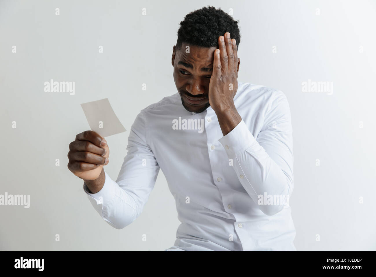Young afro man with a disappointed unhappy sad expression lost a bet on ...