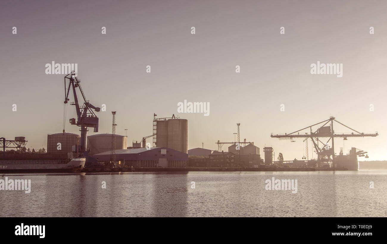 Cranes unload cargo in a seaport in Sweden Stock Photo - Alamy