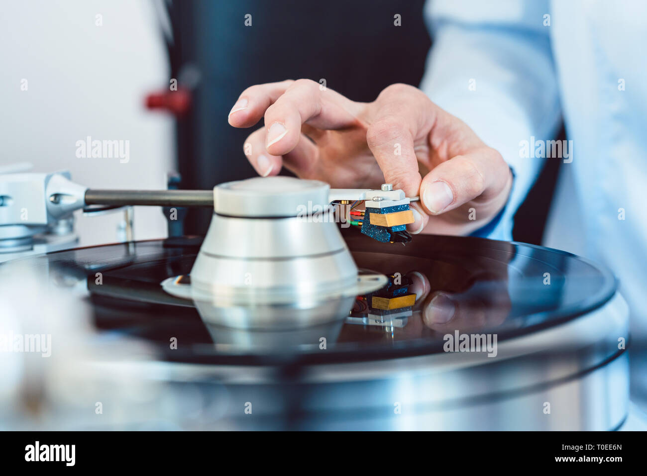 Woman putting needle on vinyl record on turntable Stock Photo - Alamy