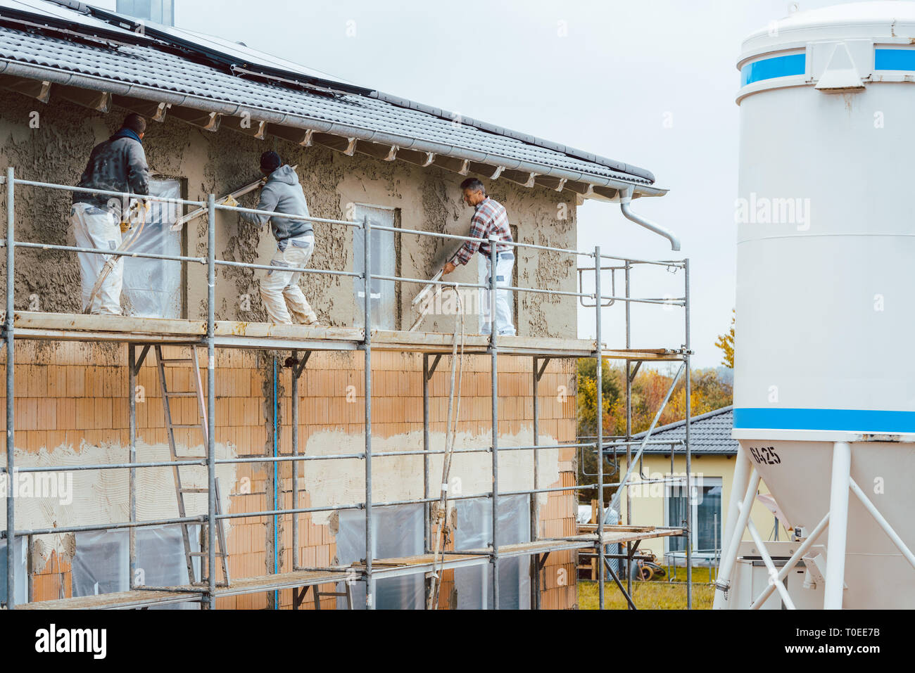Plaster worker on scaffold working Stock Photo - Alamy