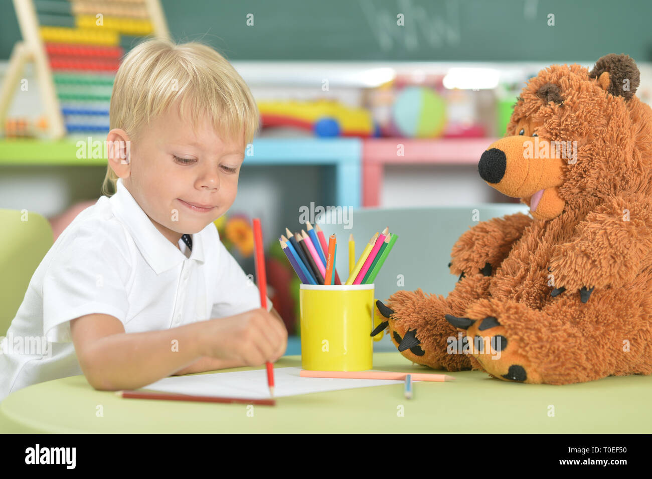 Portrait of cute little boy drawing with pencils Stock Photo - Alamy