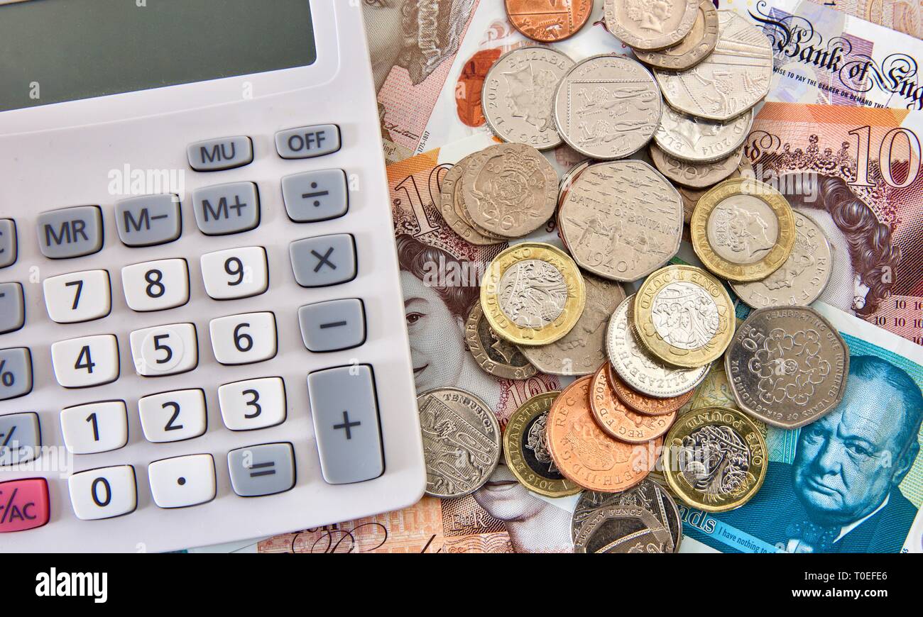 British banknotes and coins next to calculator Stock Photo - Alamy