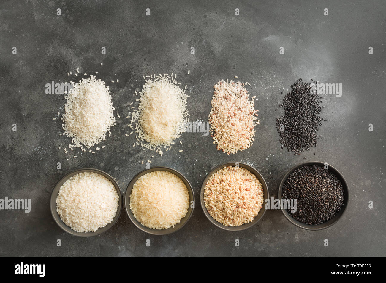 Different varieties of rice. Black rice in bowl on black background ...