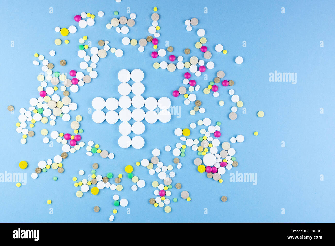 Assorted pharmaceutical medicine pills, tablets and capsules over blue ...