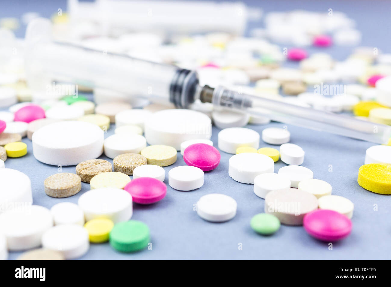 Assorted pharmaceutical medicine pills, tablets and capsules over blue ...