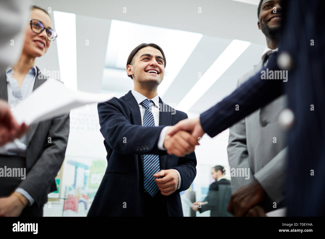 Standing leadership smiling greeting shaking hands hi-res stock ...