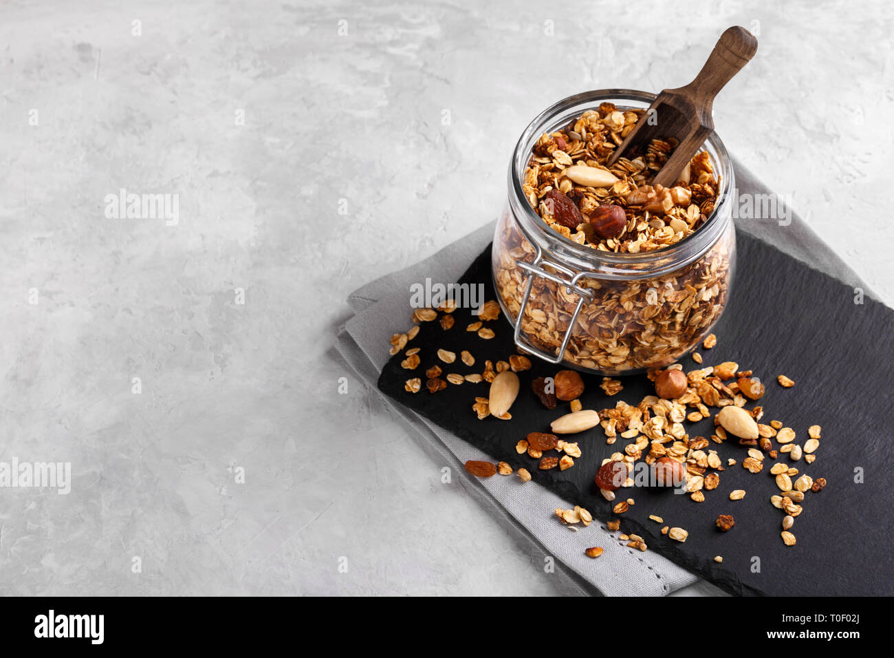 Homemade healthy granola made of oats nuts and fruits on black stone ...