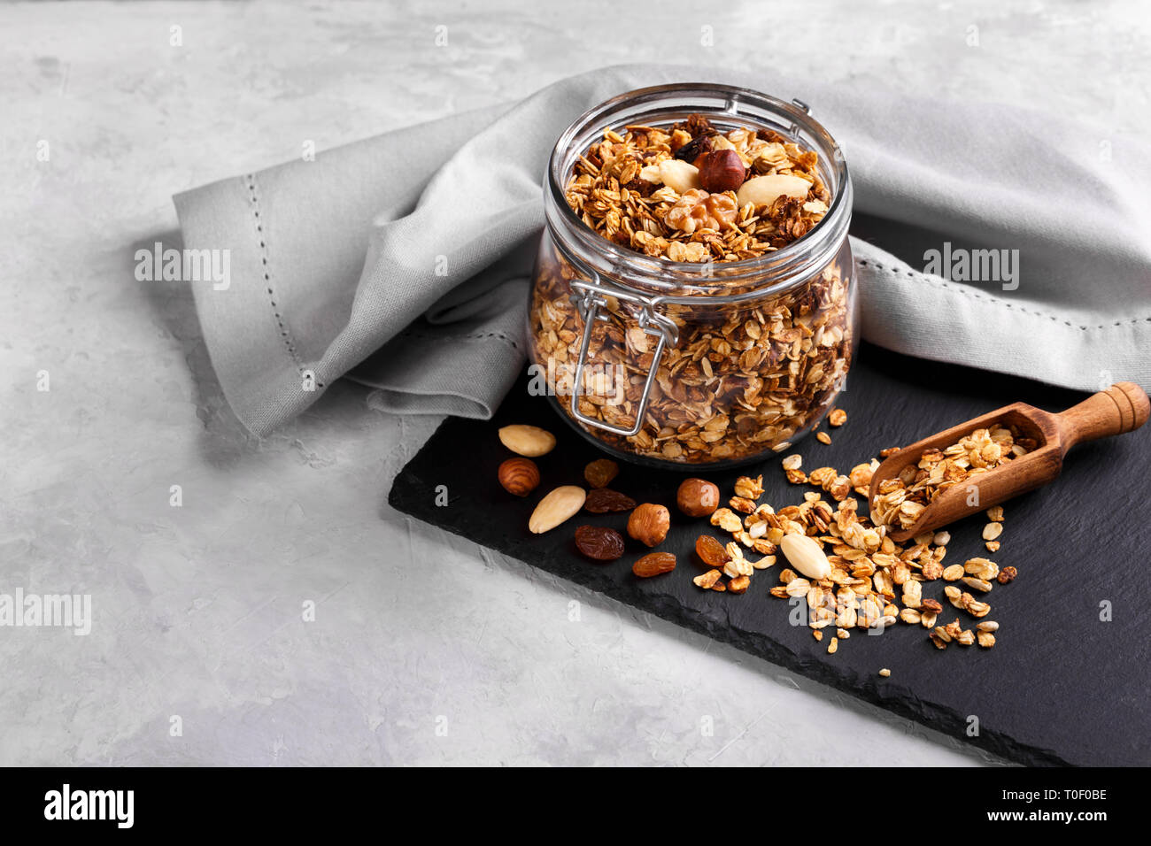 Homemade healthy granola made of oats nuts and fruits on black stone ...