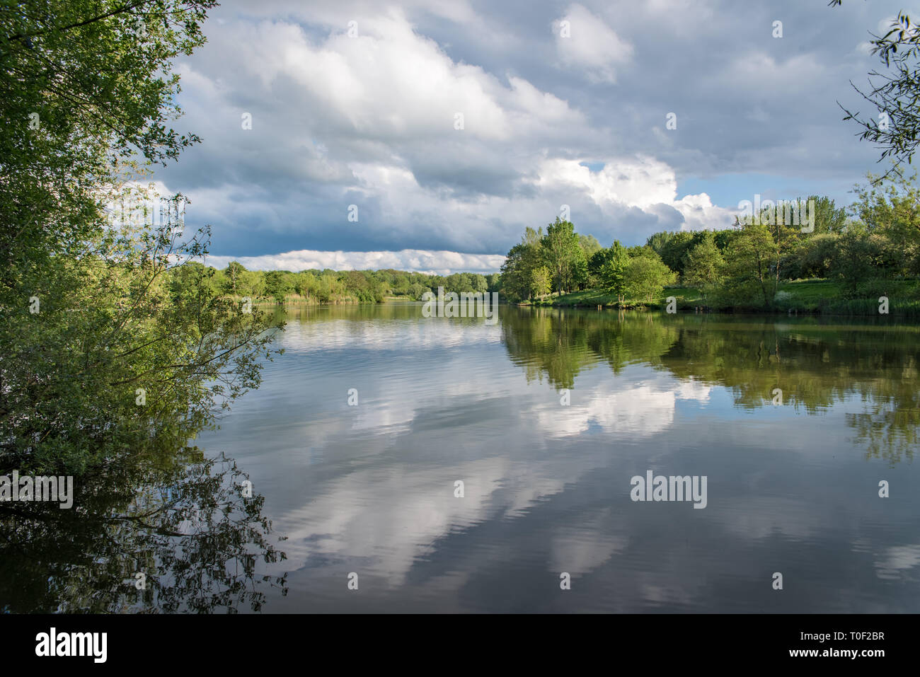 The Arrow Valley Lake in sun with clouds reflecting in the water Stock ...