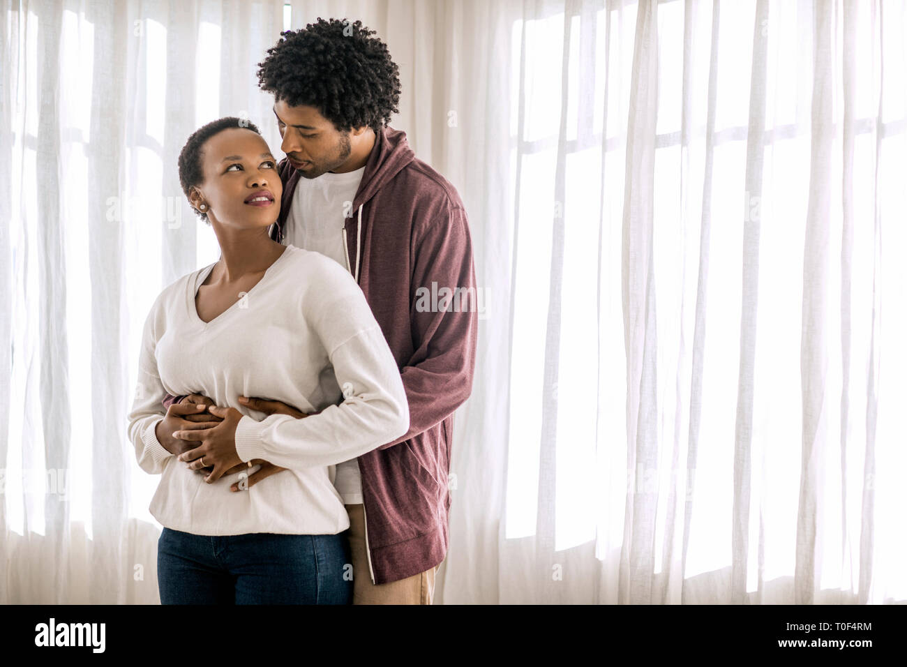 Happy young man embracing his beautiful partner Stock Photo - Alamy